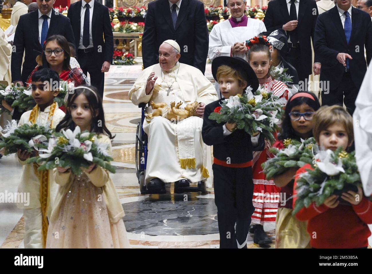 Pope Francis, in a wheel chair, holds a figurine of baby Jesus during ...