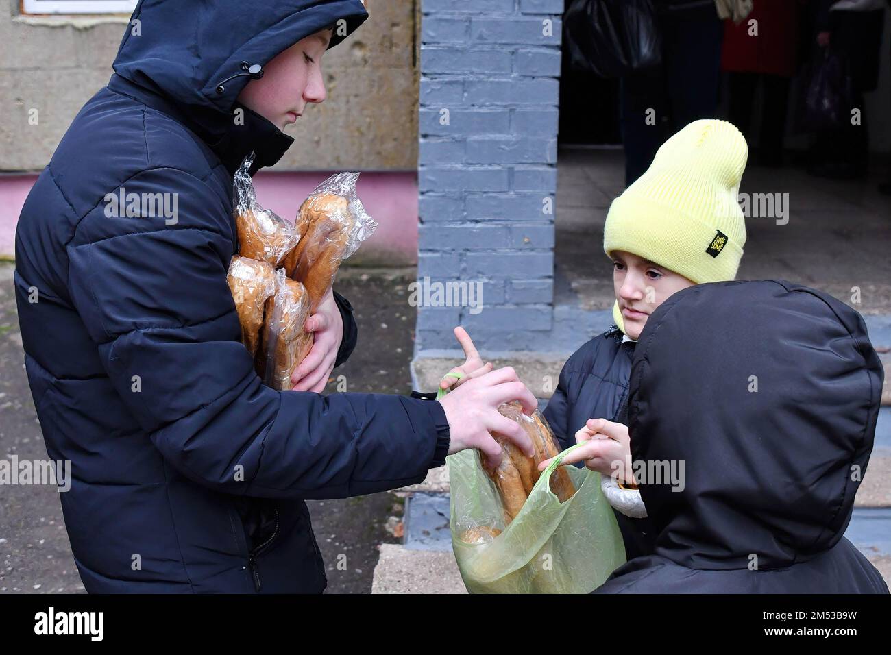 Children receive bread at a humanitarian aid distribution point in ...