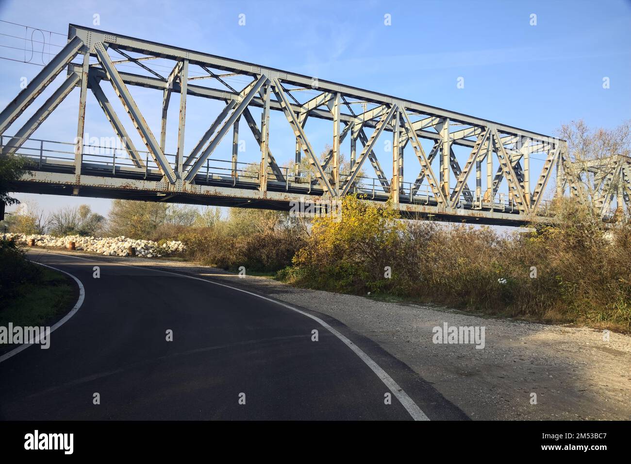 Bend in a country road under a railroad bridge Stock Photo - Alamy