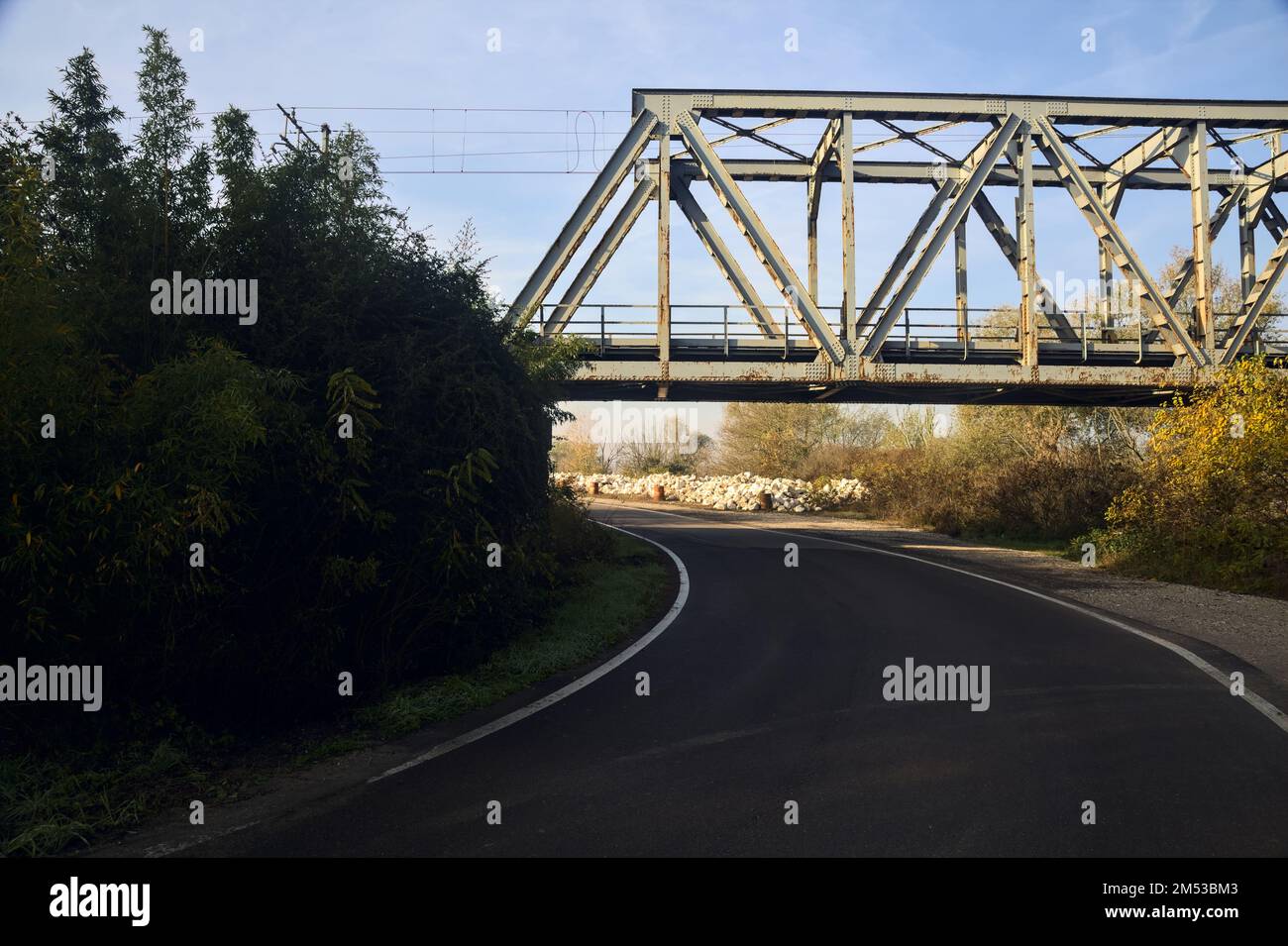 Bend in a country road under a railroad bridge Stock Photo - Alamy