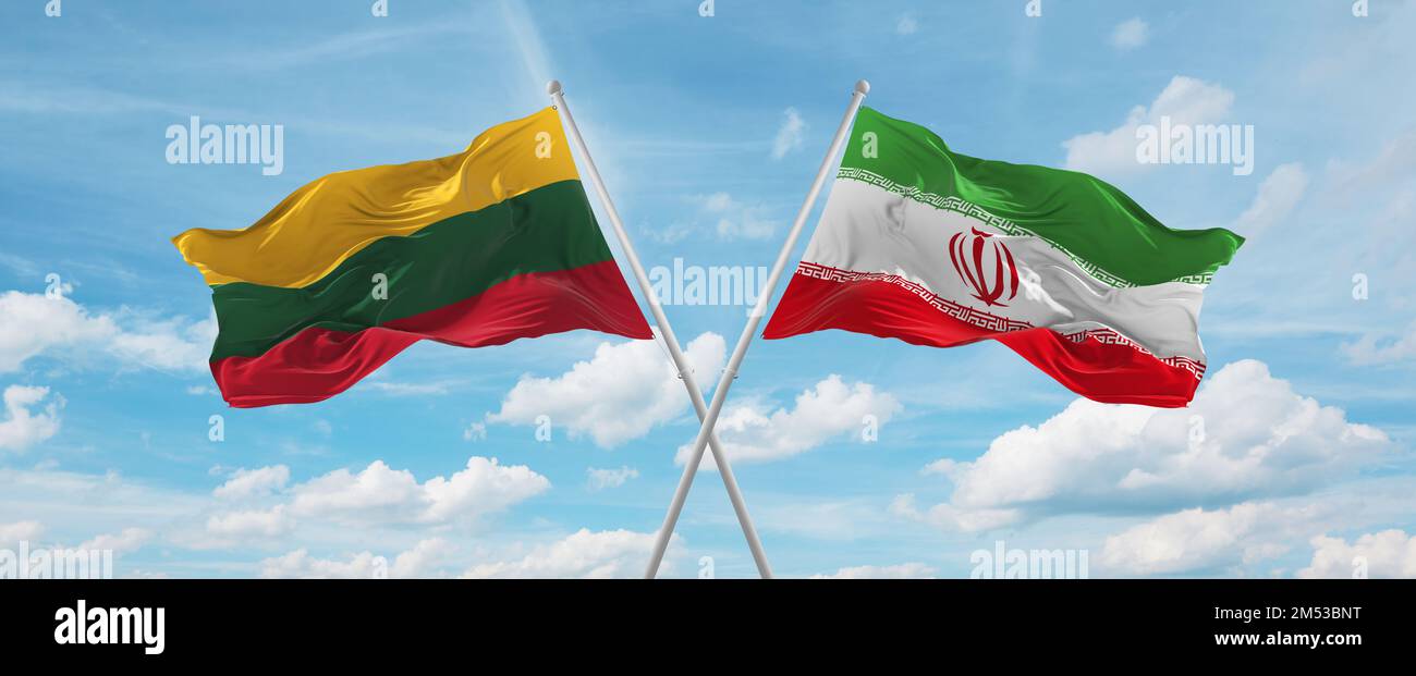two crossed flags Iran and Lithuania waving in wind at cloudy sky ...