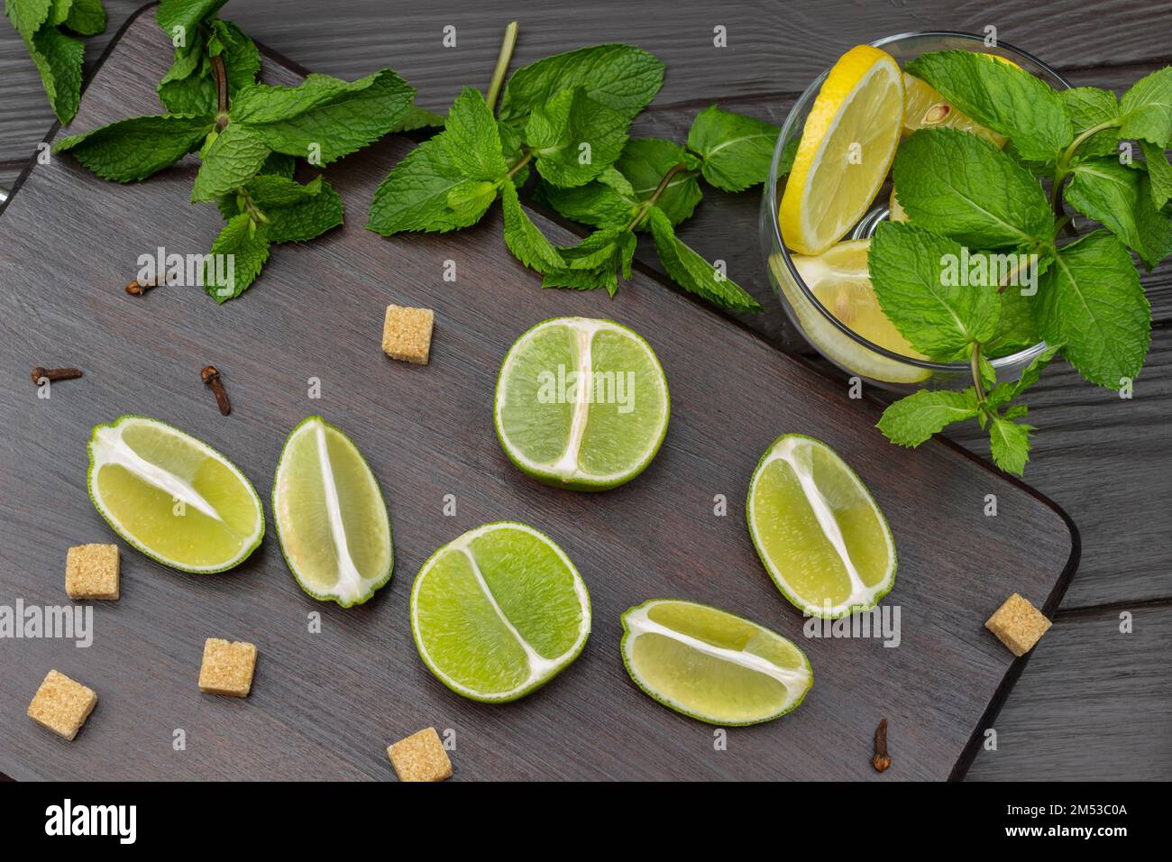 Sliced fresh lemon. Mint and lemon in a glass bowl. Flat lay. Dark ...