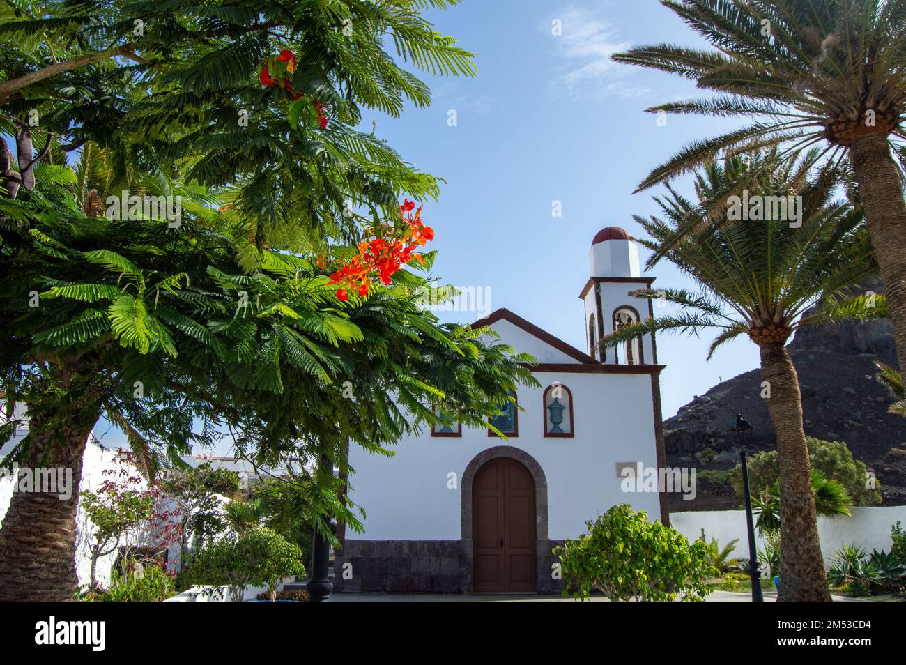 A white church building surrounded by tropical trees in the Canary ...