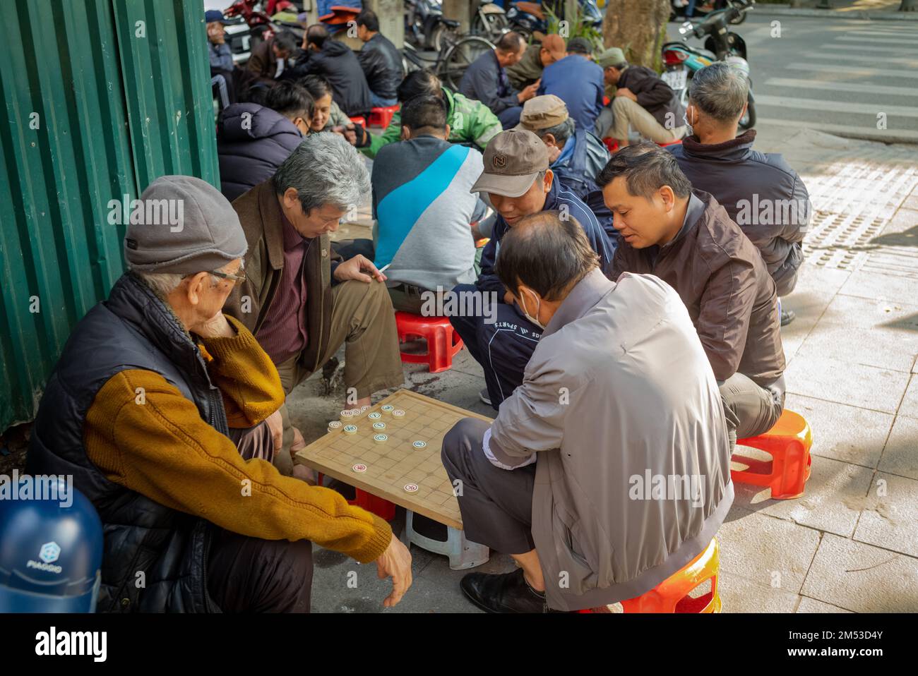 Vietnamese men play Chinese chess omn the pavement in the centre of ...
