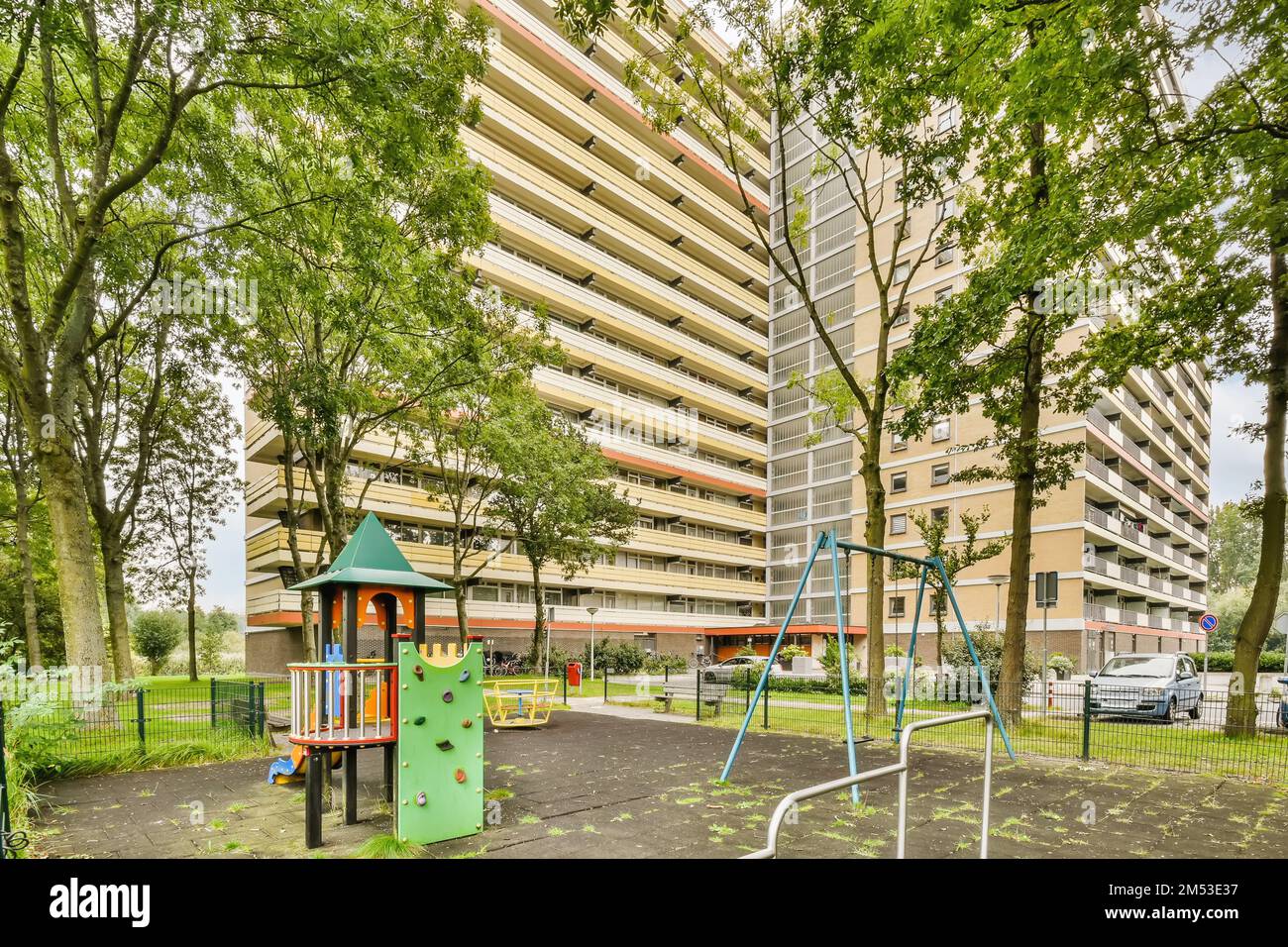 an empty playground in front of a multi - storey apartment building ...
