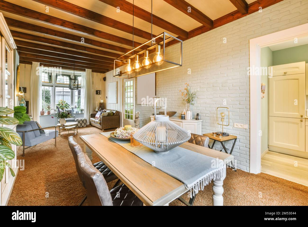 a dining room with wood beams and white brick on the wall behind it is ...