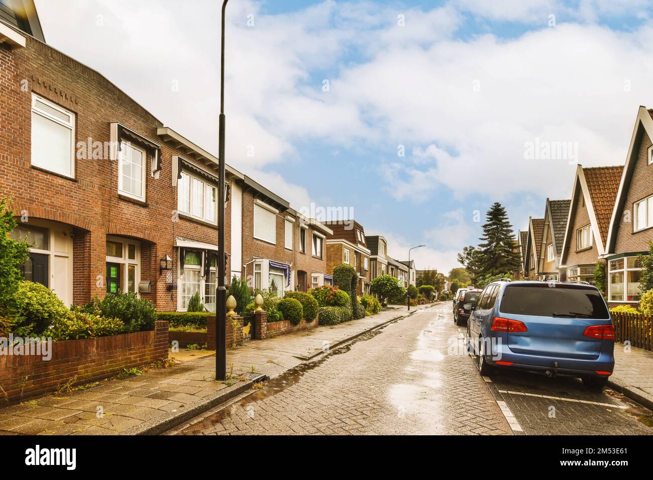 a car parked on the side of a street in a residential area, with houses ...