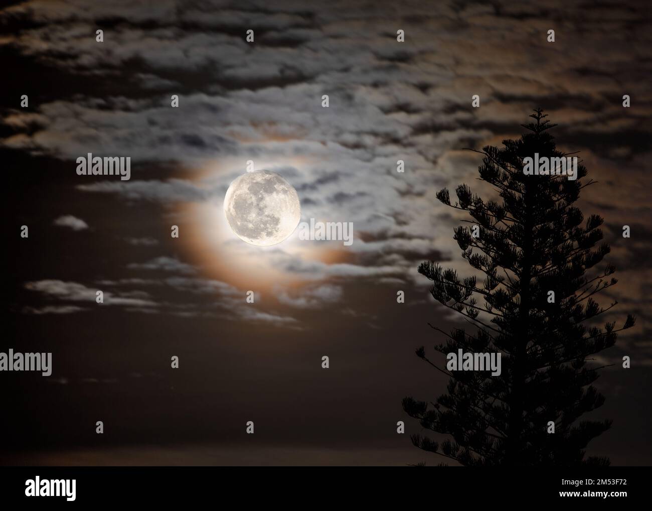 A beautiful shot of a shining full moon behind clouds in the sky Stock ...