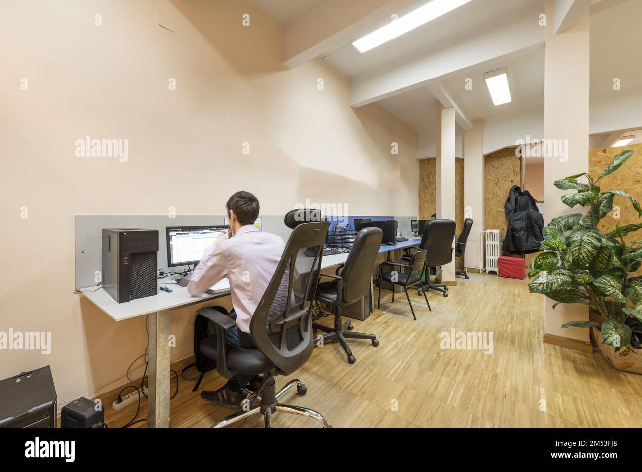 Workstations at a long table in an office with industrial oak parquet ...