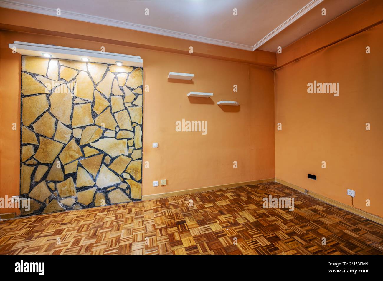 Empty room with peach colored walls, absurd stonework on the wall, oak ...