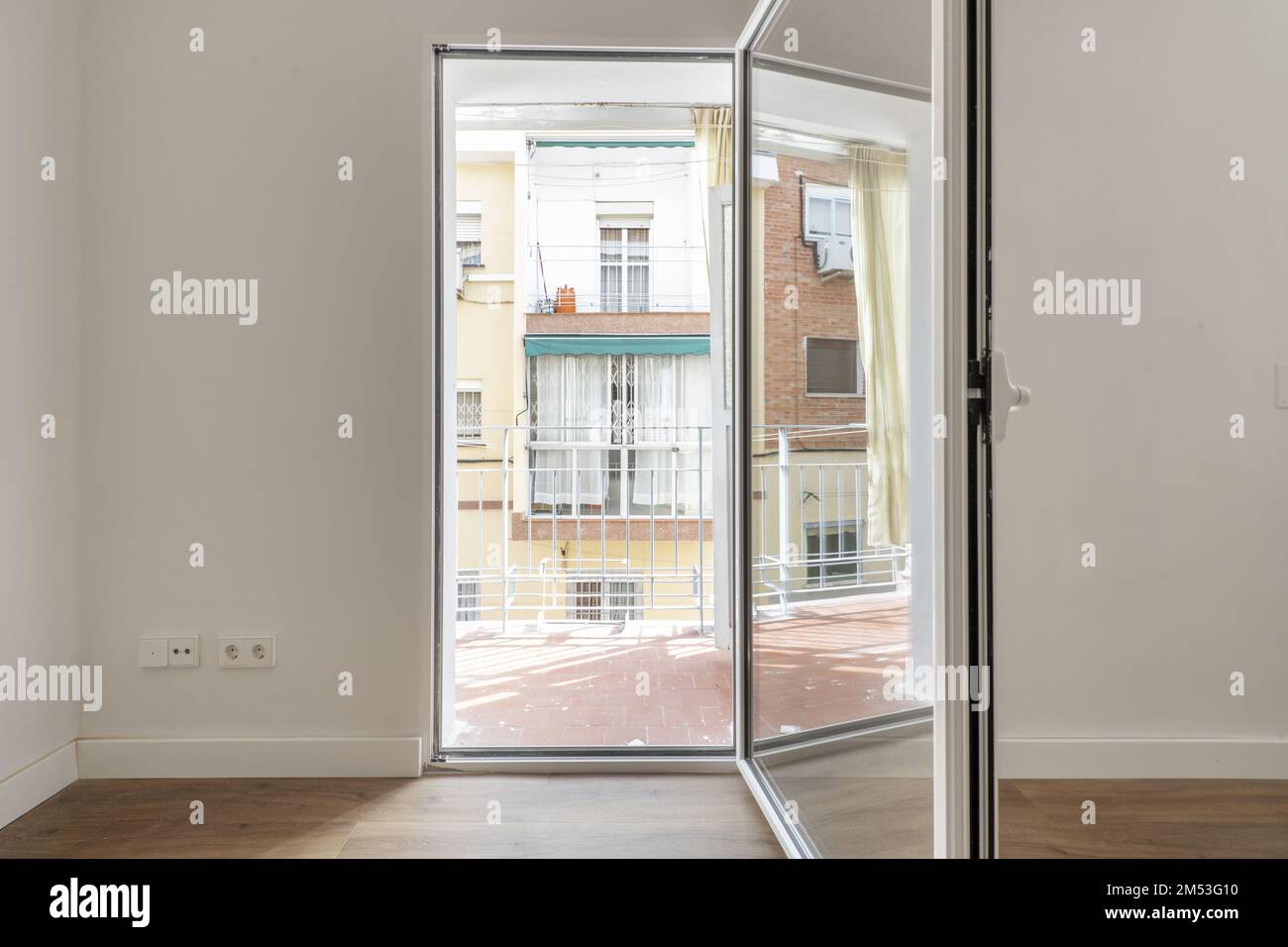 An empty room with access to a small terrace with views Stock Photo - Alamy