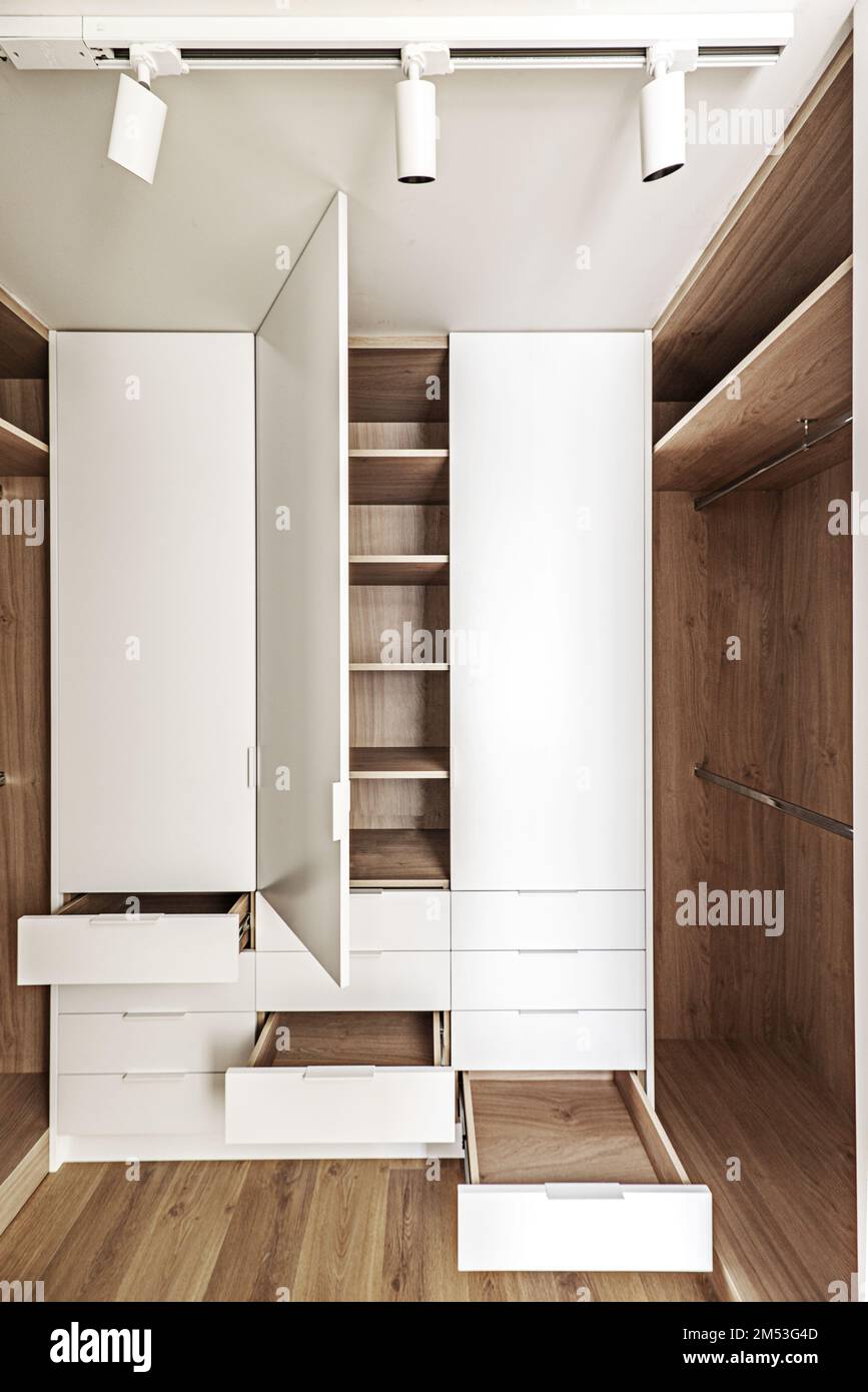 A white wooden cabinet inside a dressing room with many open and closed ...