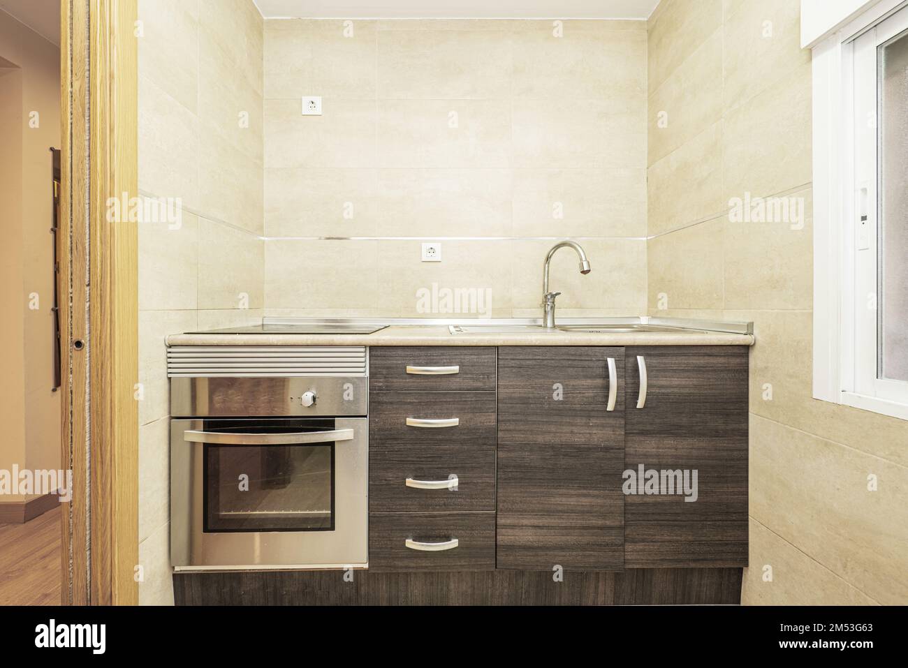 Room with kitchen base units with ceramic hob without extractor hood ...