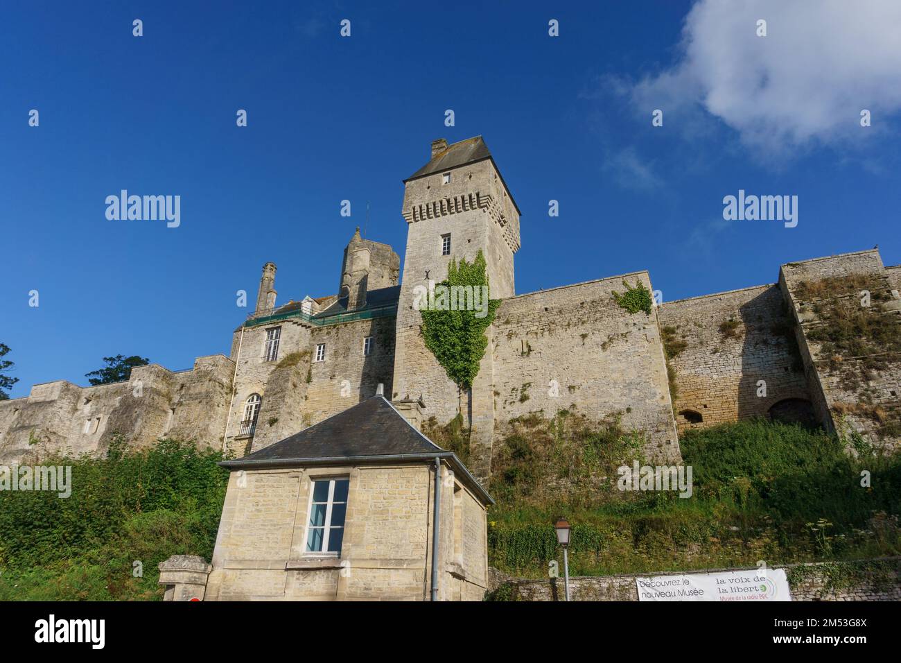 Chateau de Creully castle on a sunny summer evening with blue sky ...