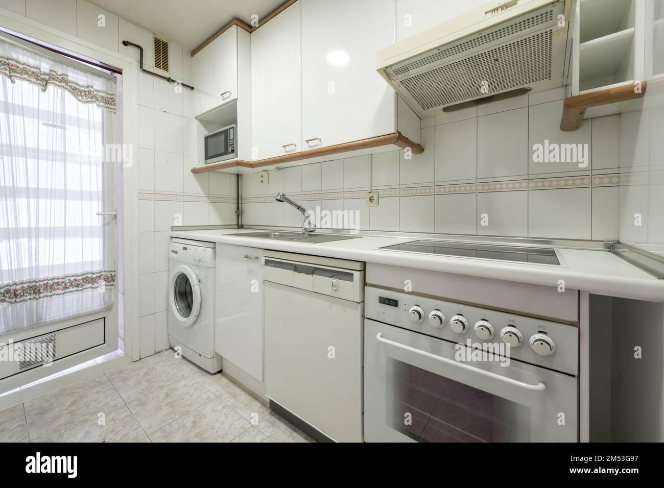 Front of a small kitchen with white cabinets with matching appliances ...