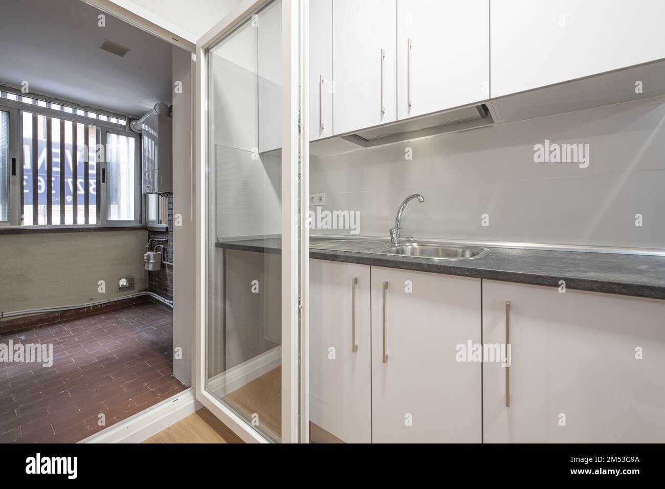 Front of a small kitchen with white cabinets with built-in appliances ...