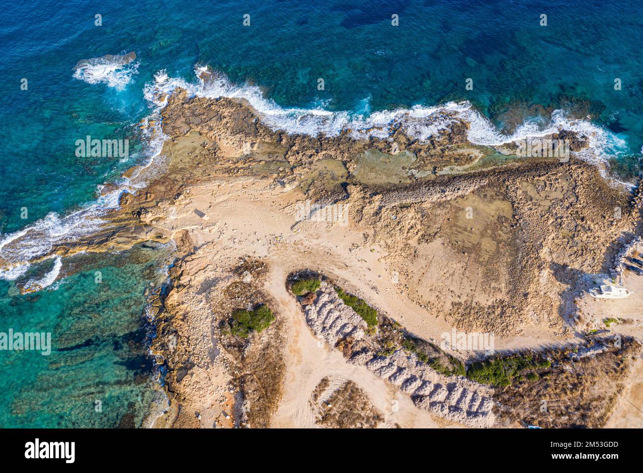 An aerial of the foamy waves of the turquoise South Cyprus sea watering ...