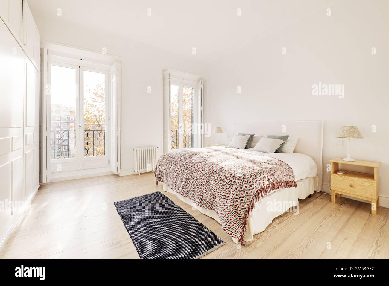 Double bedroom with a large bed, wooden bedside tables, large windows ...