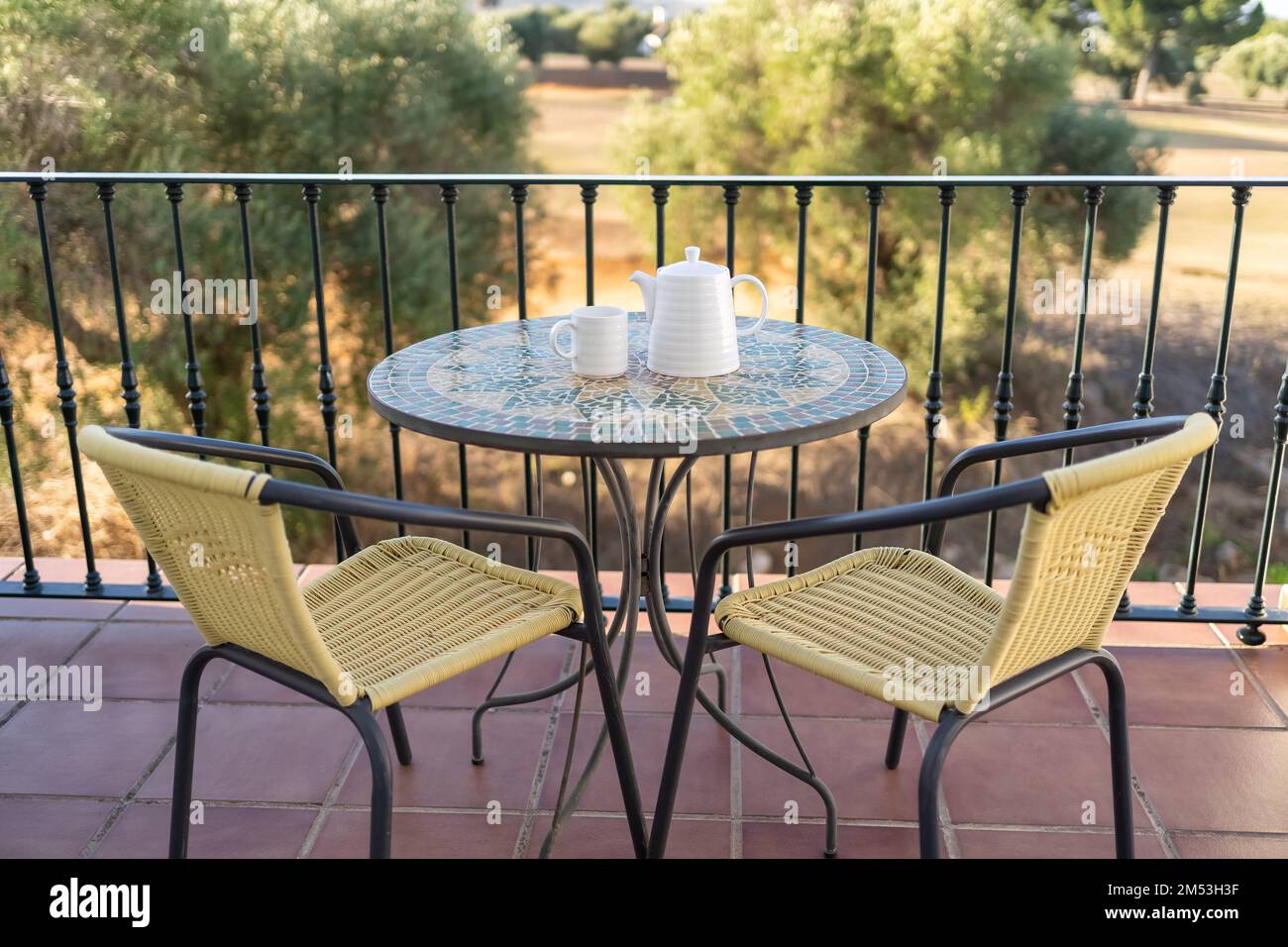 Apartment terrace with table and two chairs and views of the outside ...