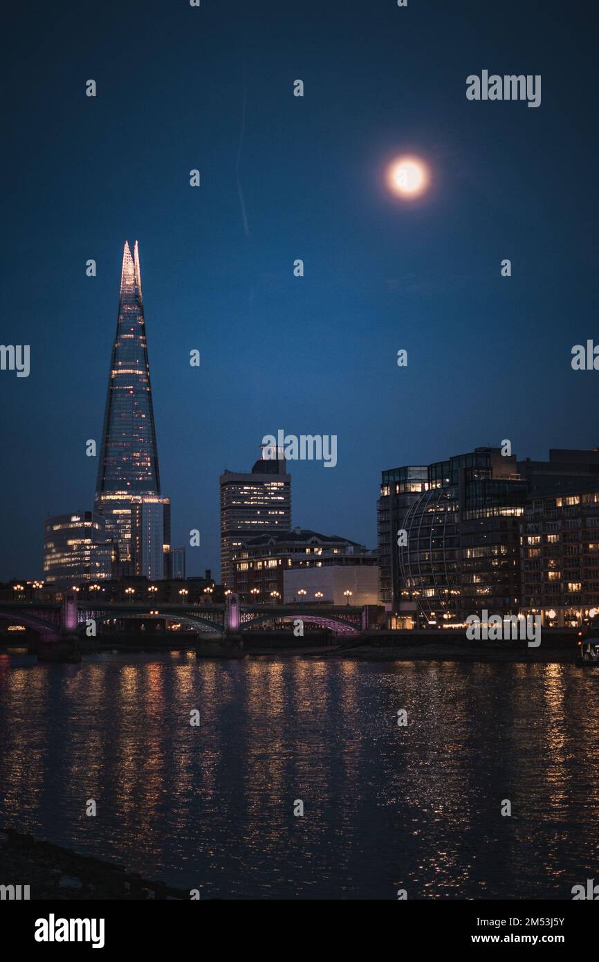 A London skyline background with illuminated buildings and The Shard at ...