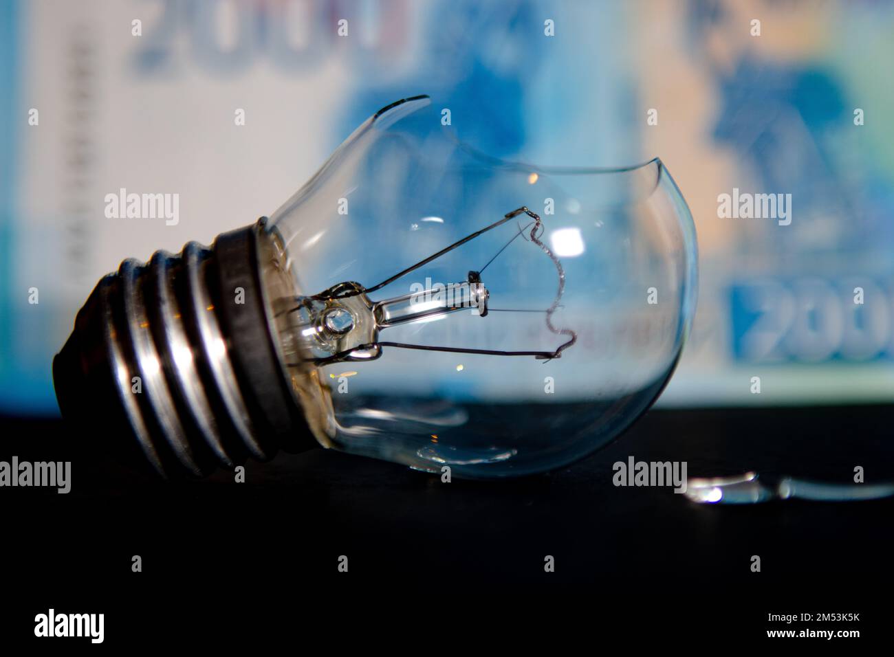 Broken light bulb with pieces of glass on blur background Russian ruble ...