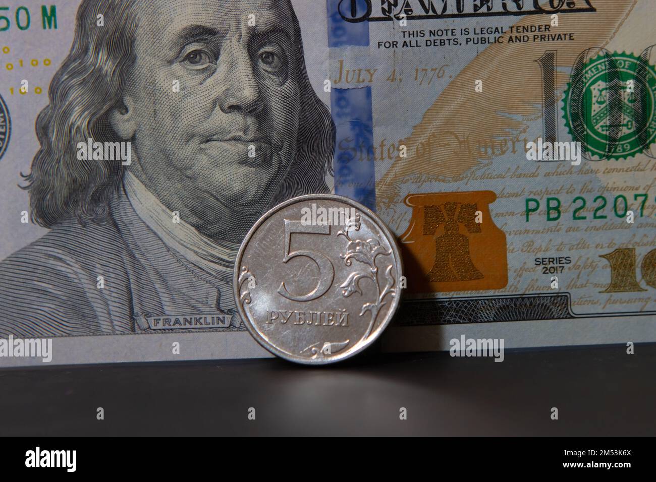 5 Russian ruble on a 100-dollar bill. The concept of the economic ...