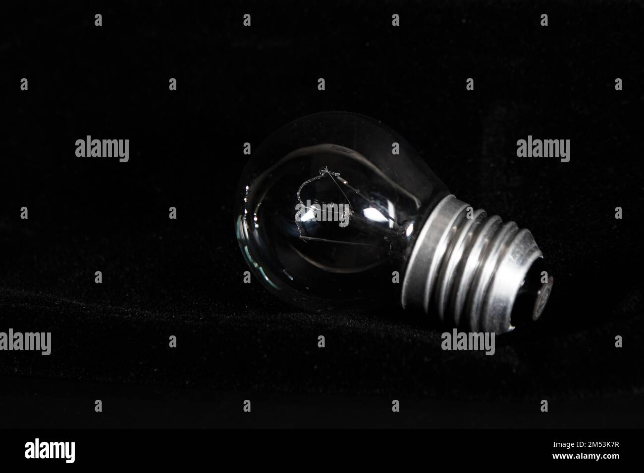 Broken light bulb on black background. Concept of electricity prices ...