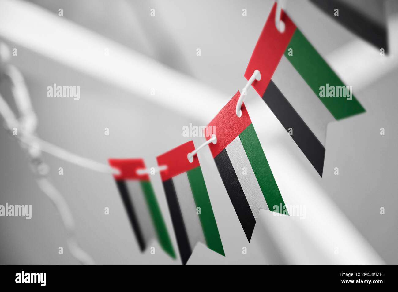 A garland of United Arab Emirates national flags on an abstract blurred ...