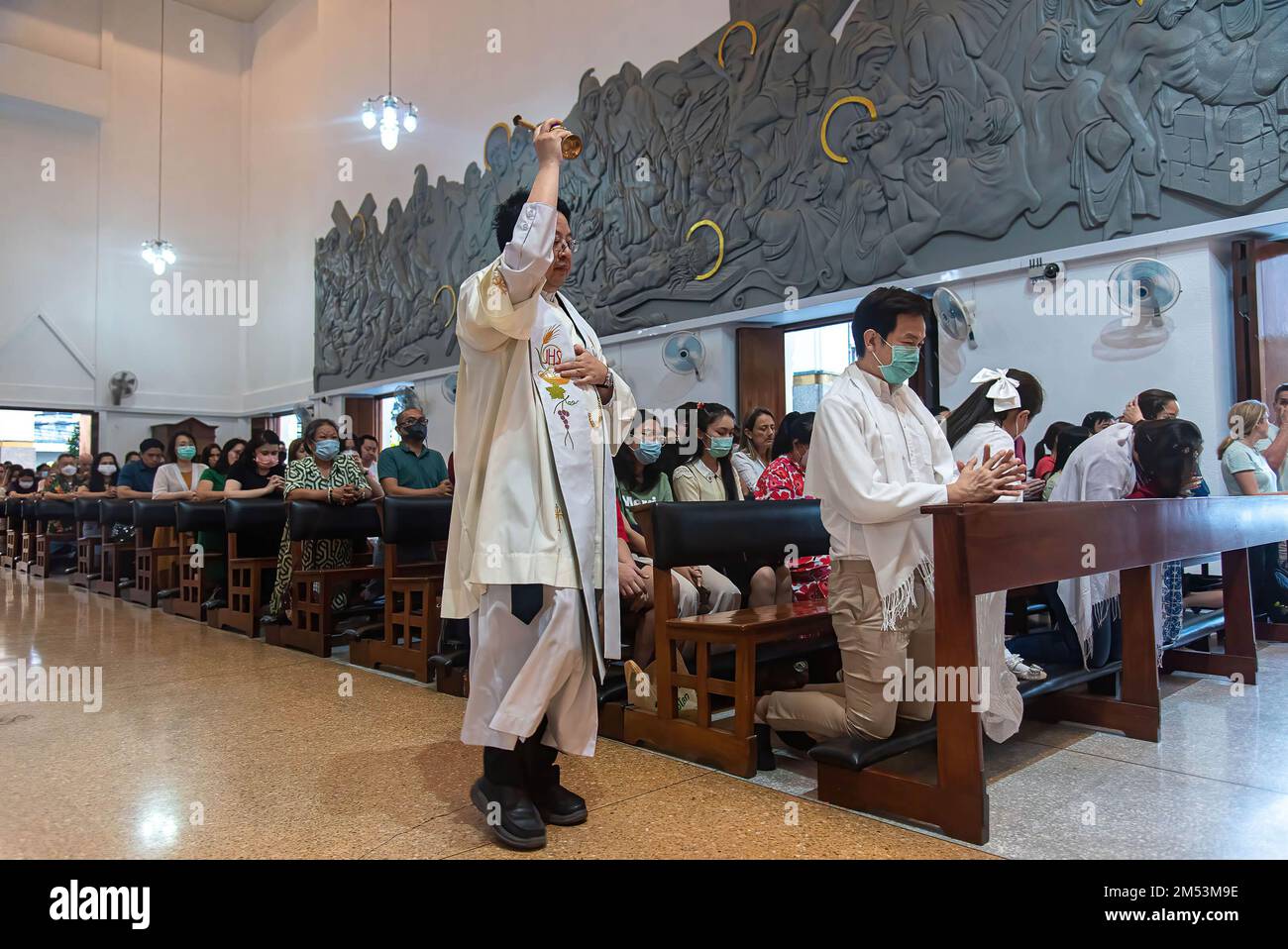 A Catholic priest seen sprinkling a holy water during the Christmas day ...