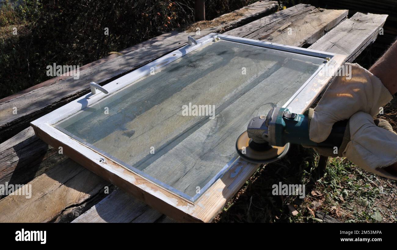 processing the surface of a painted window frame with an emery nozzle ...