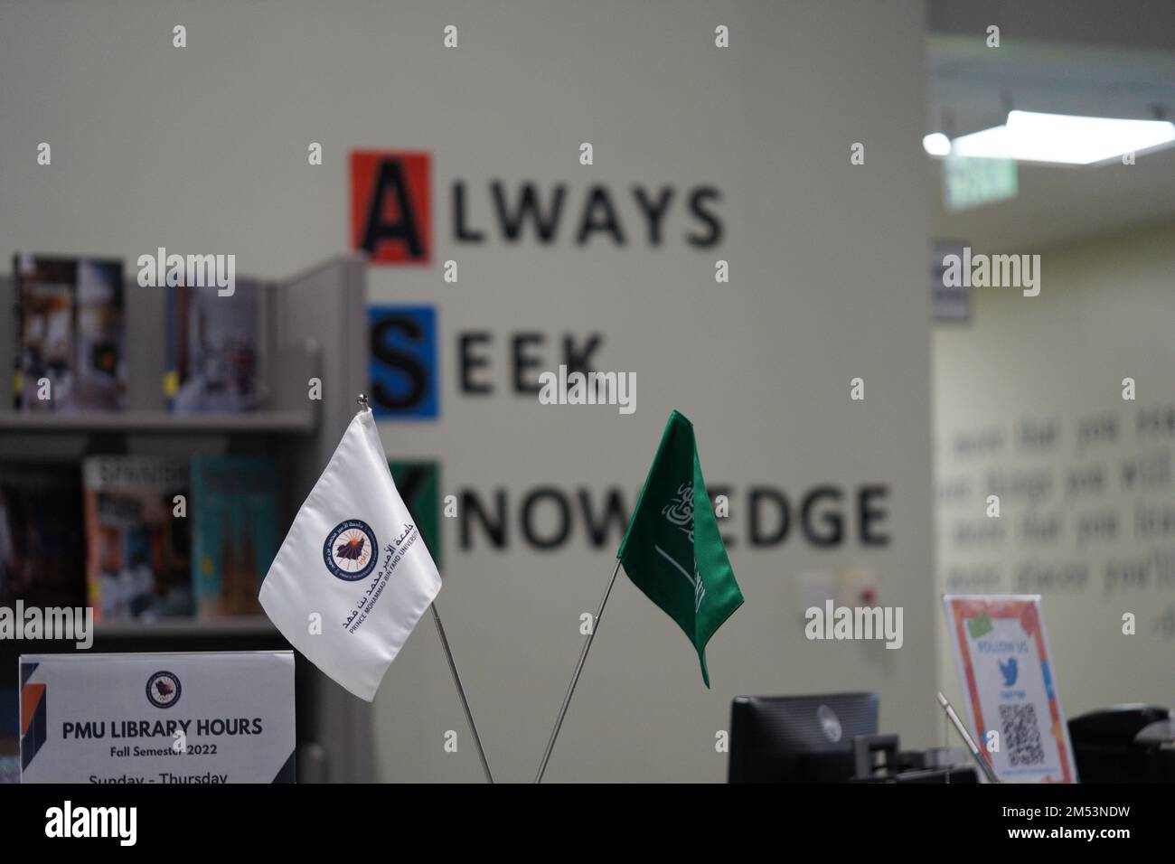 University and country flags at the desk of a library office. Prince ...