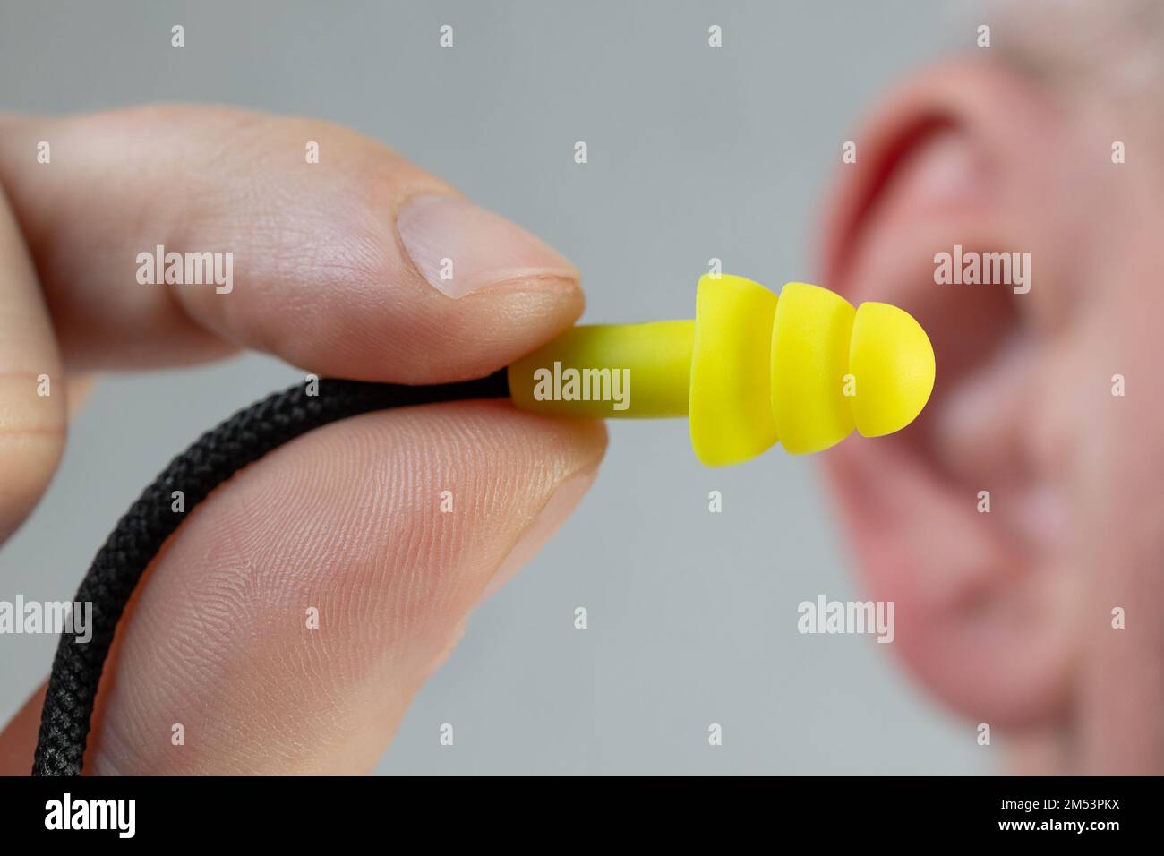 Silicone earplugs of a man, holds in his fingers on a white background ...