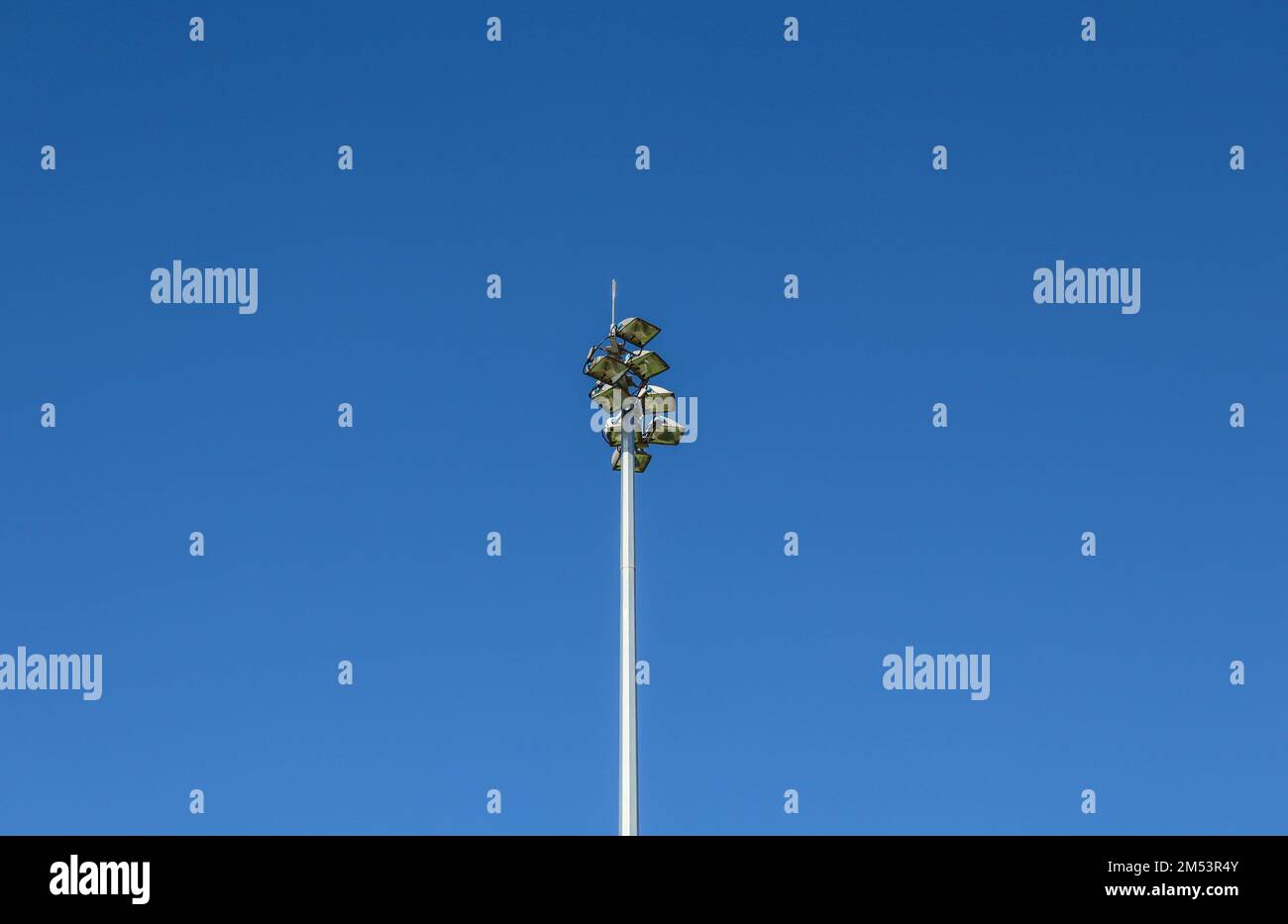 A long pole with lamps on the street in sunny weather in blue sky ...
