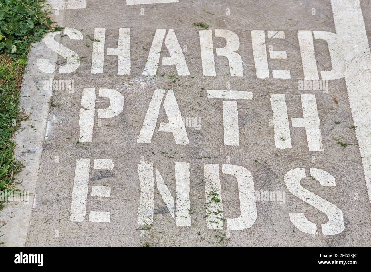 A close-up shot of "shared path ends" road marking on a path Stock ...