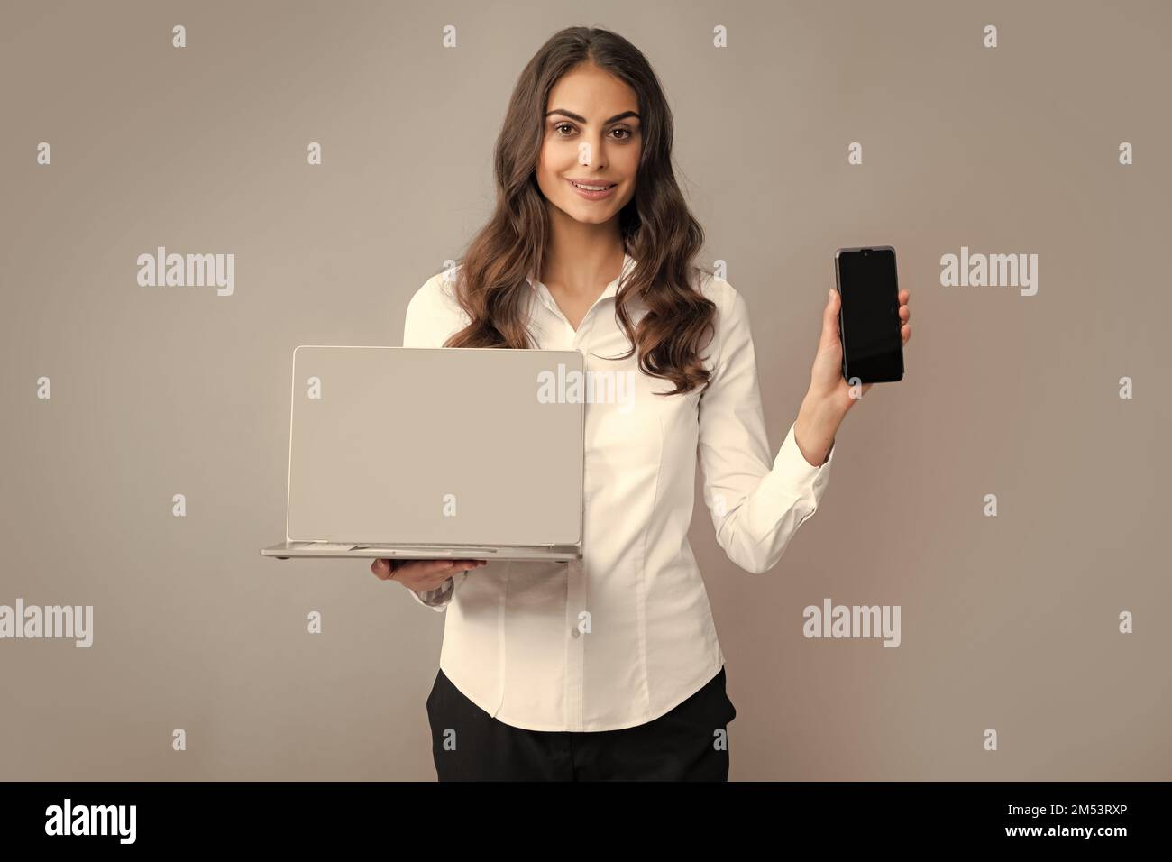 Happy girl using mobile phone and laptop. Woman showing empty laptop ...