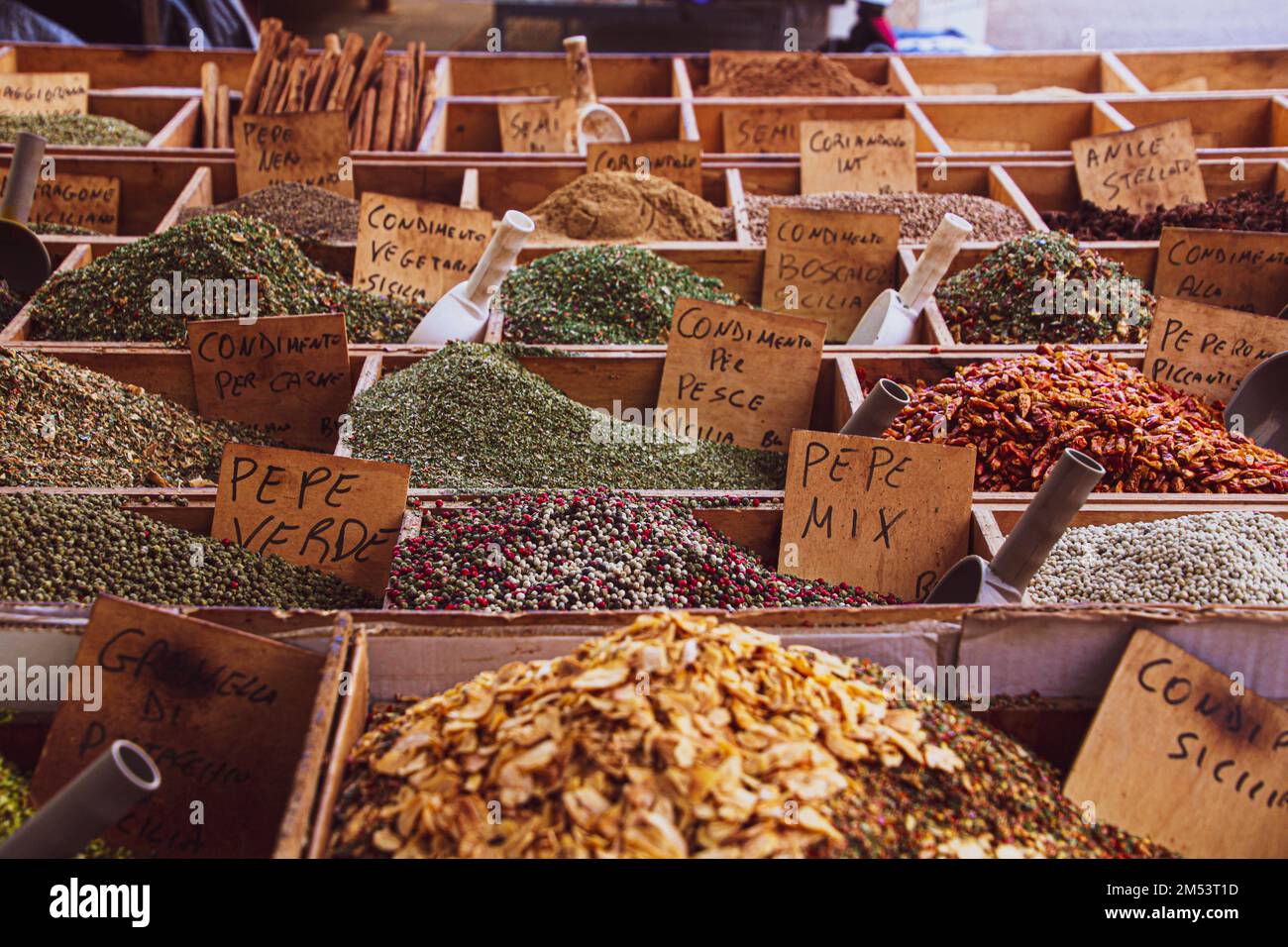 A closeup of spices in a store in Italy with their names written on ...