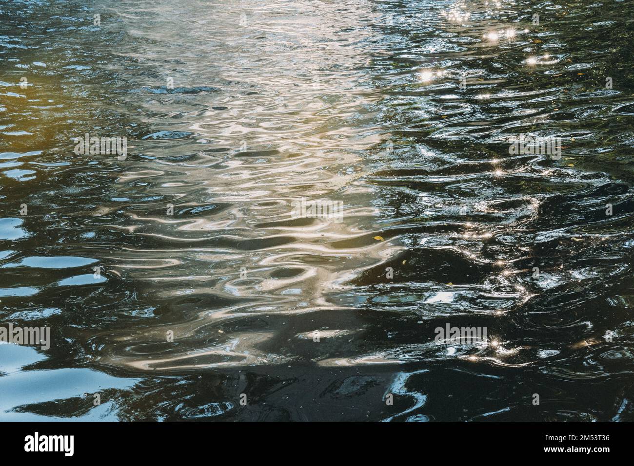 A surface of water with the reflection of sun rays Stock Photo - Alamy