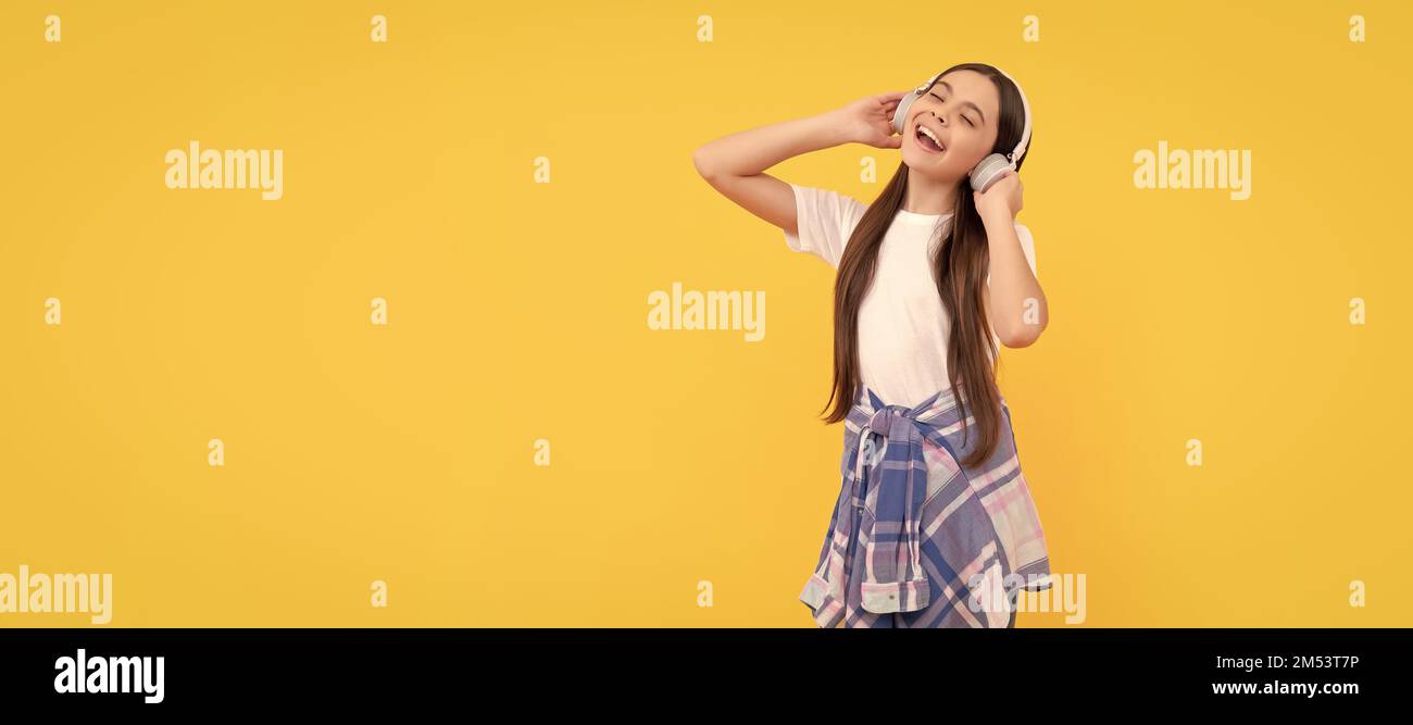 Happy kid in headphones enjoy singing song yellow background. Child ...