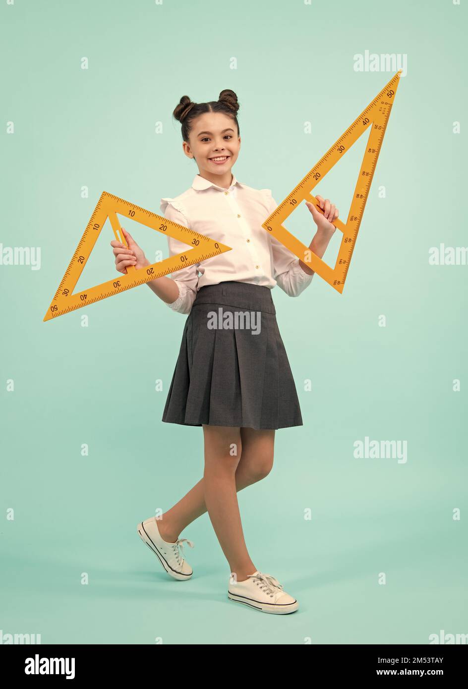 Measuring school equipment. Schoolgirl holding measure for geometry ...