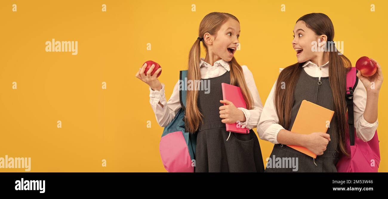 School girls friends. Surprised children hold apples. . Horizontal ...