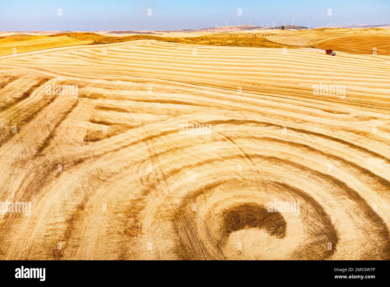 An aerial shot of golden wheat fields in the rolling hills of the ...