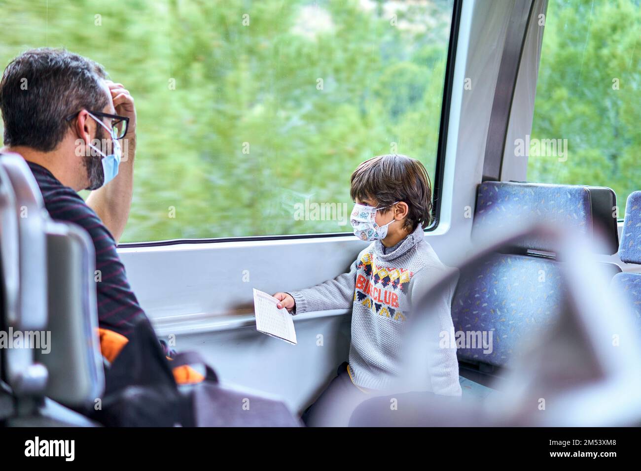 father and son talking while travelling in a train Stock Photo - Alamy