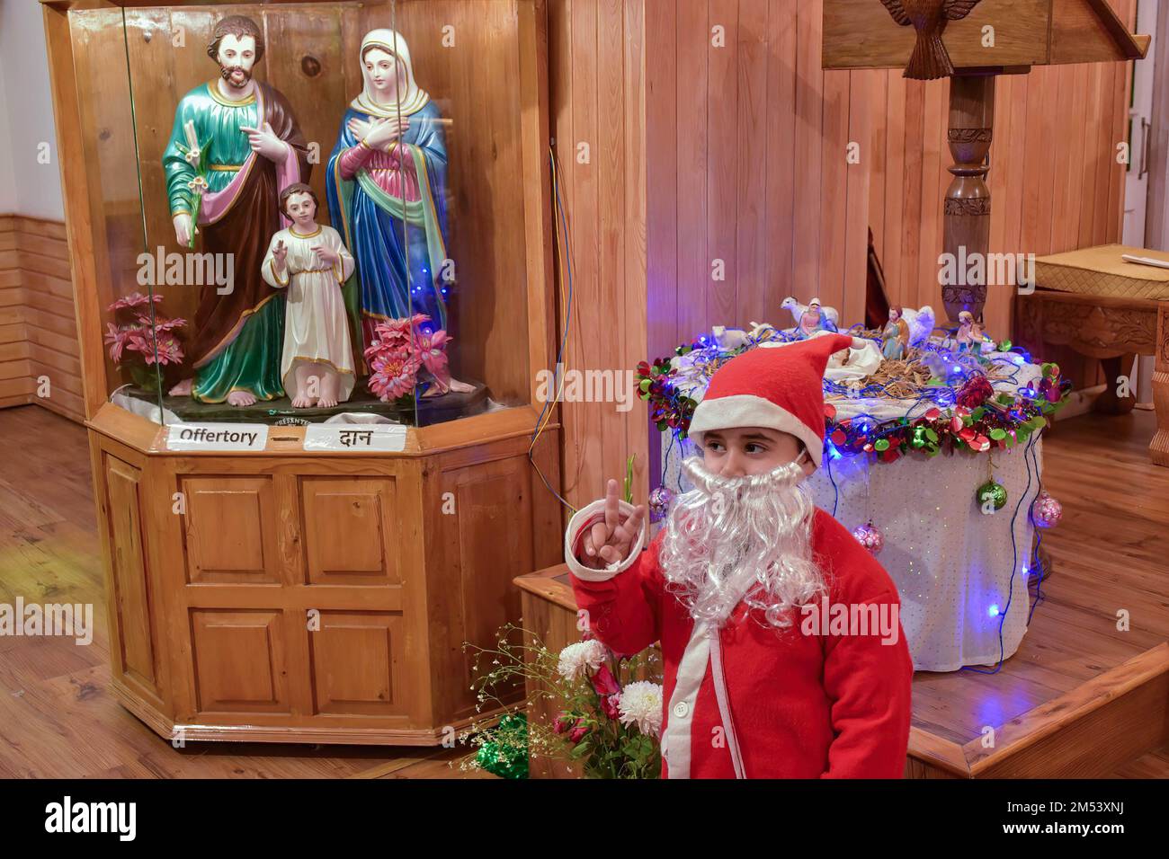 A young Christian devotee wears a Santa Clause attire as he poses for ...