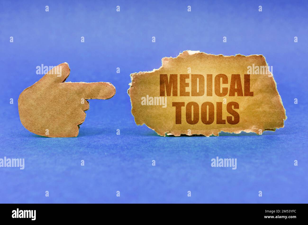 Medical concept. On a blue surface, a cardboard hand points to a sign ...