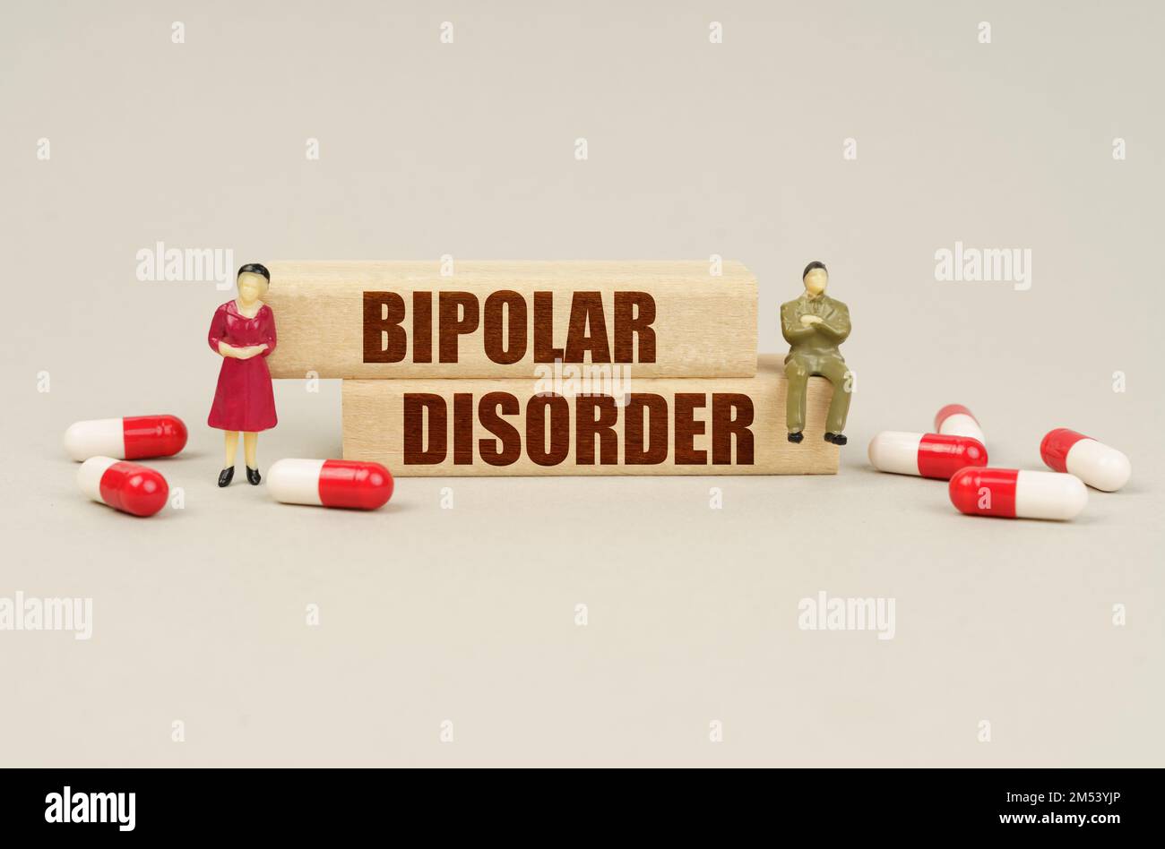 Medical concept. Next to the miniature figurines of people are tablets ...