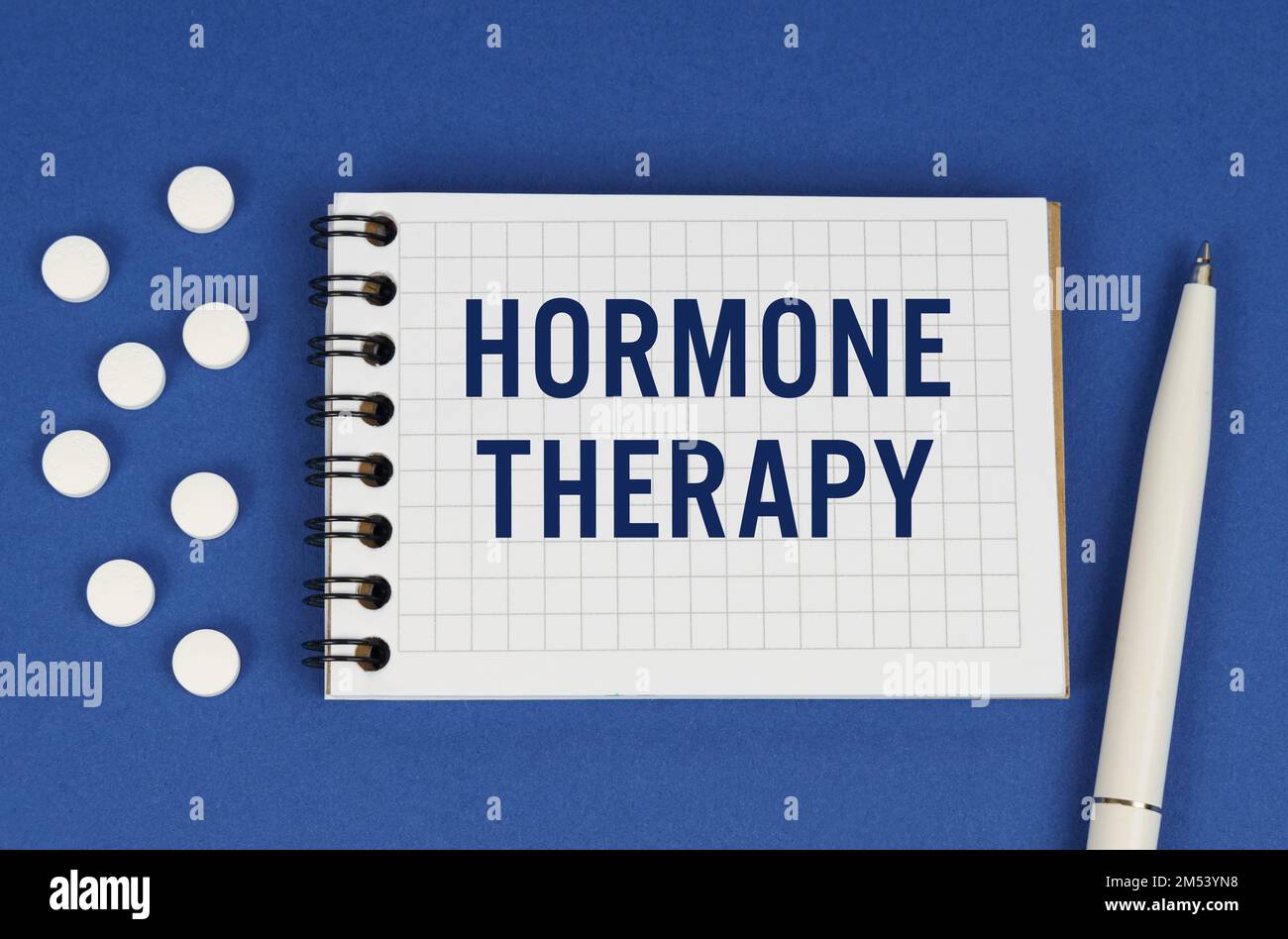 Medical concept. On a blue background, a pen, tablets and a notepad ...