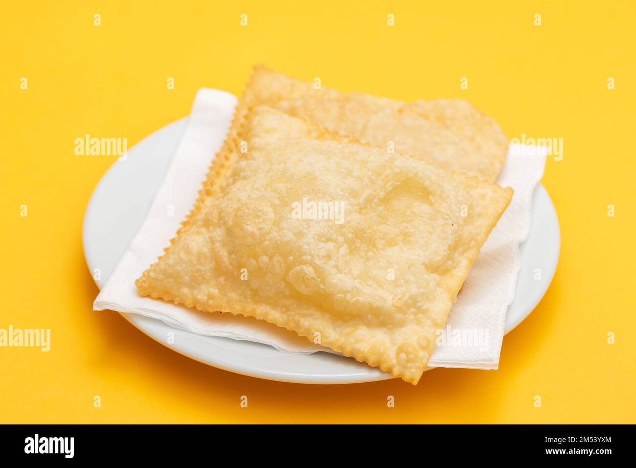 typical brazilian fried pastry on white small plate Stock Photo - Alamy