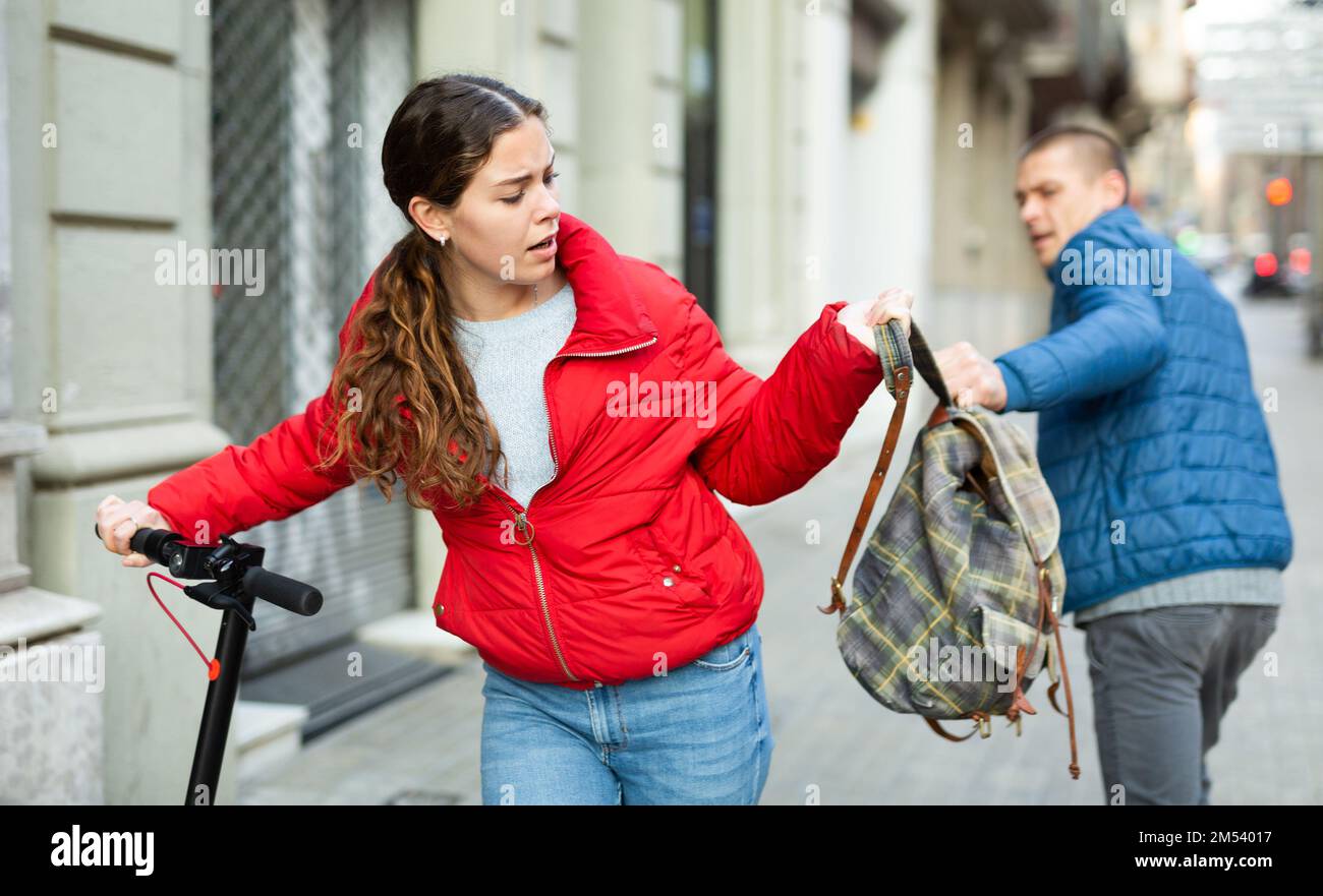Angry young male thief stealing handbag Stock Photo - Alamy