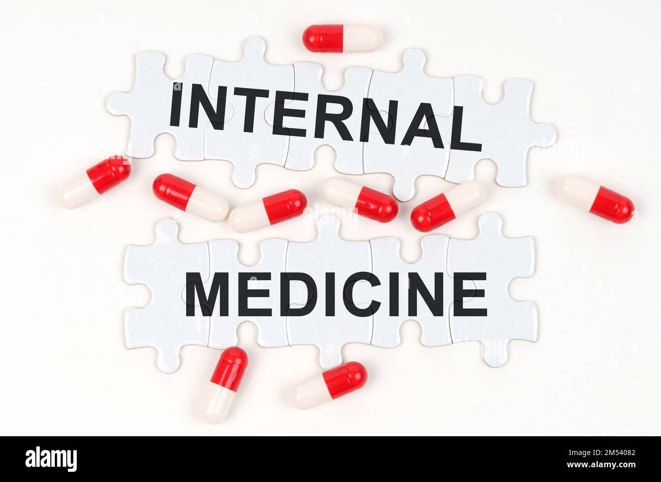Medical concept. On a white surface, tablets and puzzles with the ...