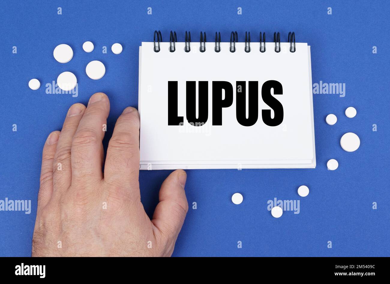 Medical concept. On the blue surface of the tablet, a hand and a ...